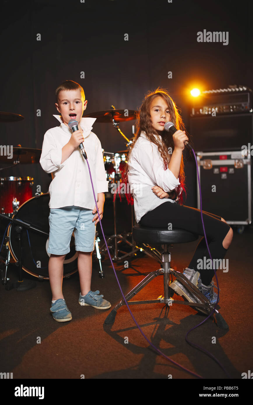 little boy and girl singing in recording studio Stock Photo - Alamy
