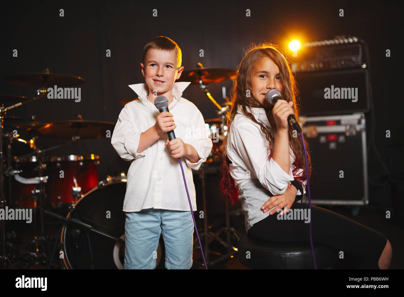 little boy and girl singing in recording studio Stock Photo - Alamy