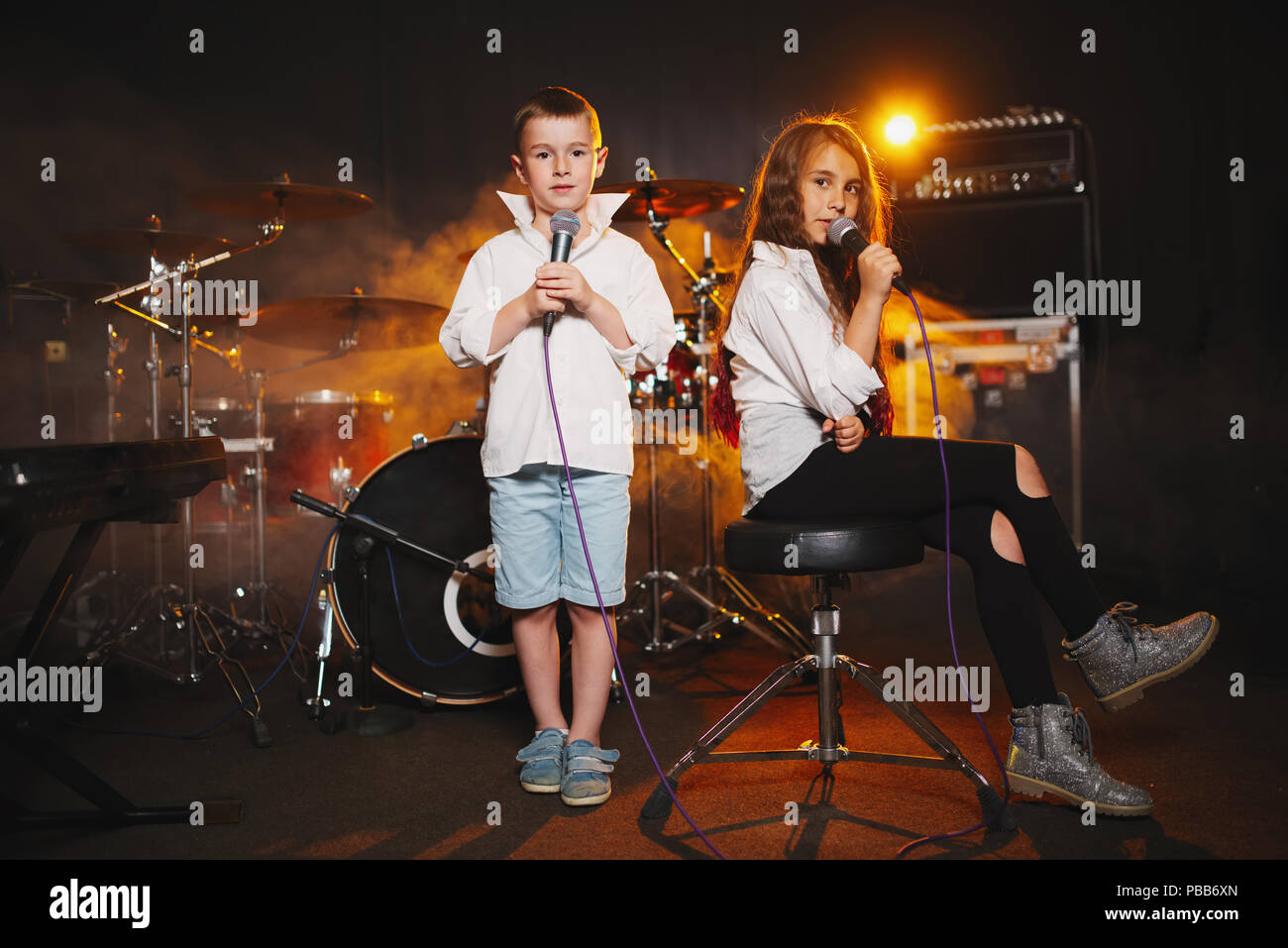 little boy and girl singing in recording studio Stock Photo - Alamy