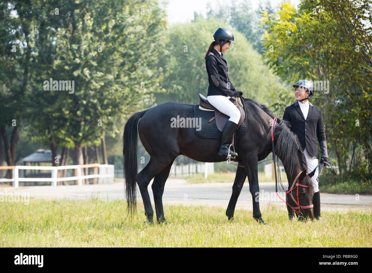 Cheerful Chinese couple riding horse Stock Photo - Alamy