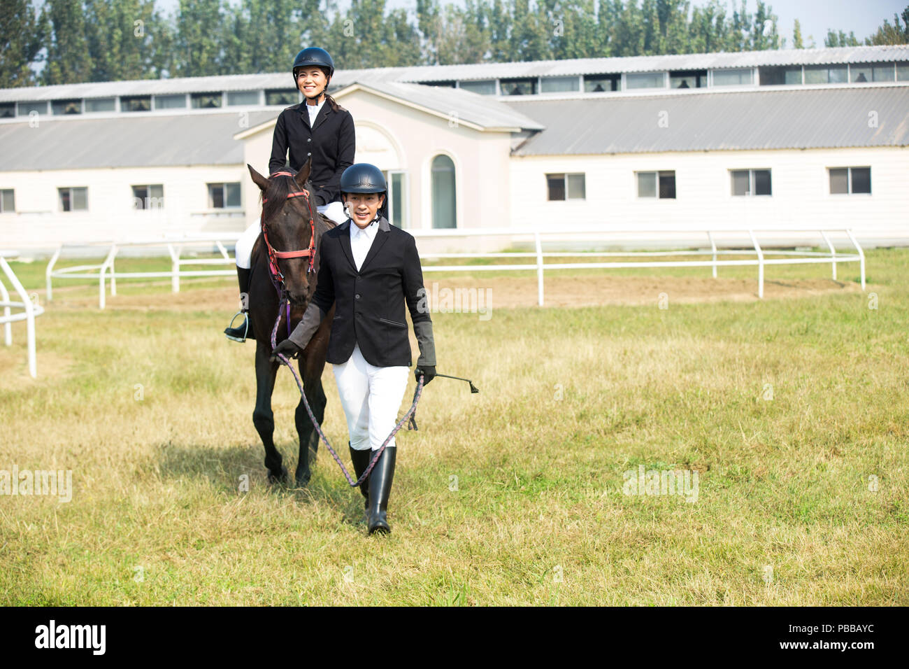 Cheerful Chinese couple riding horse Stock Photo - Alamy