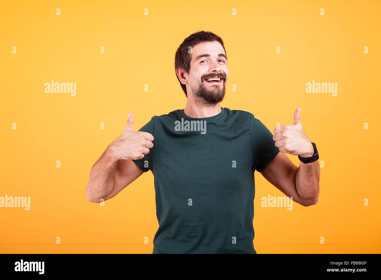 Happy smiling trendy guy showing thumbs up on yellow background. Cool ...