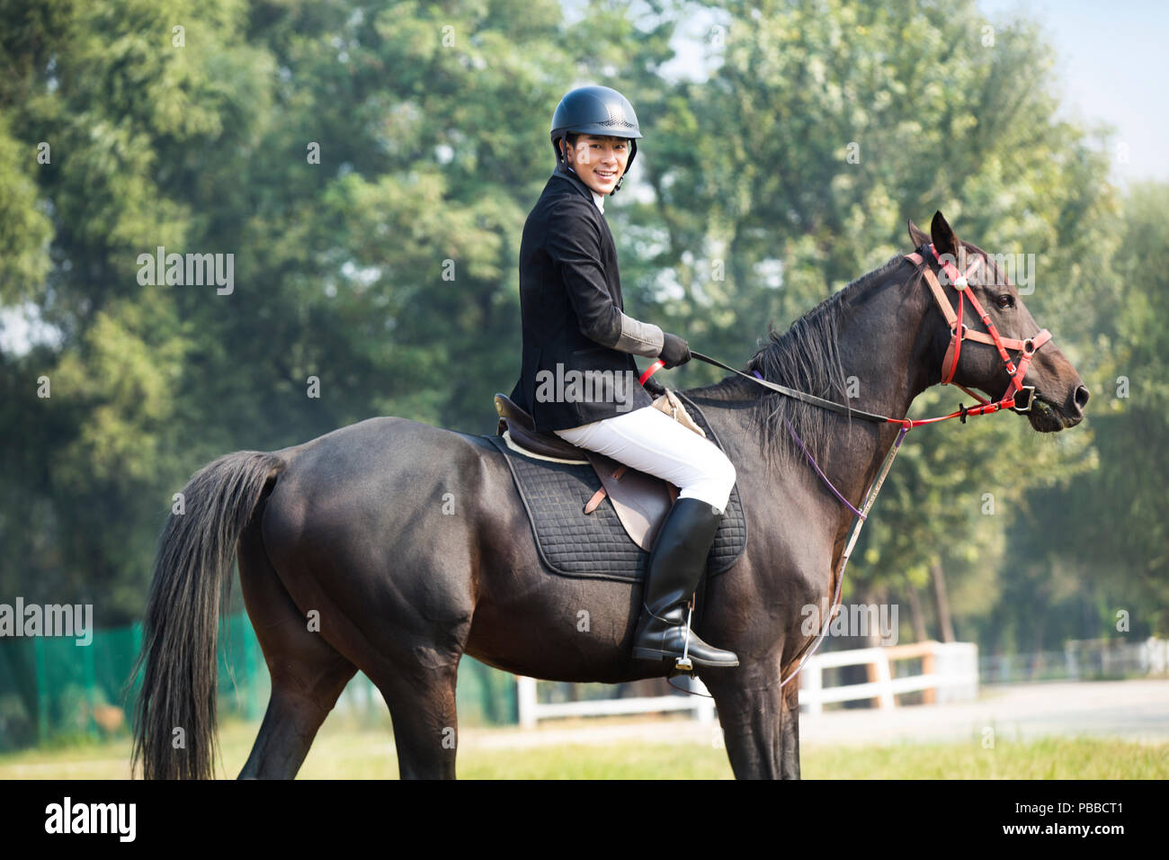 Young Chinese man riding horse Stock Photo - Alamy