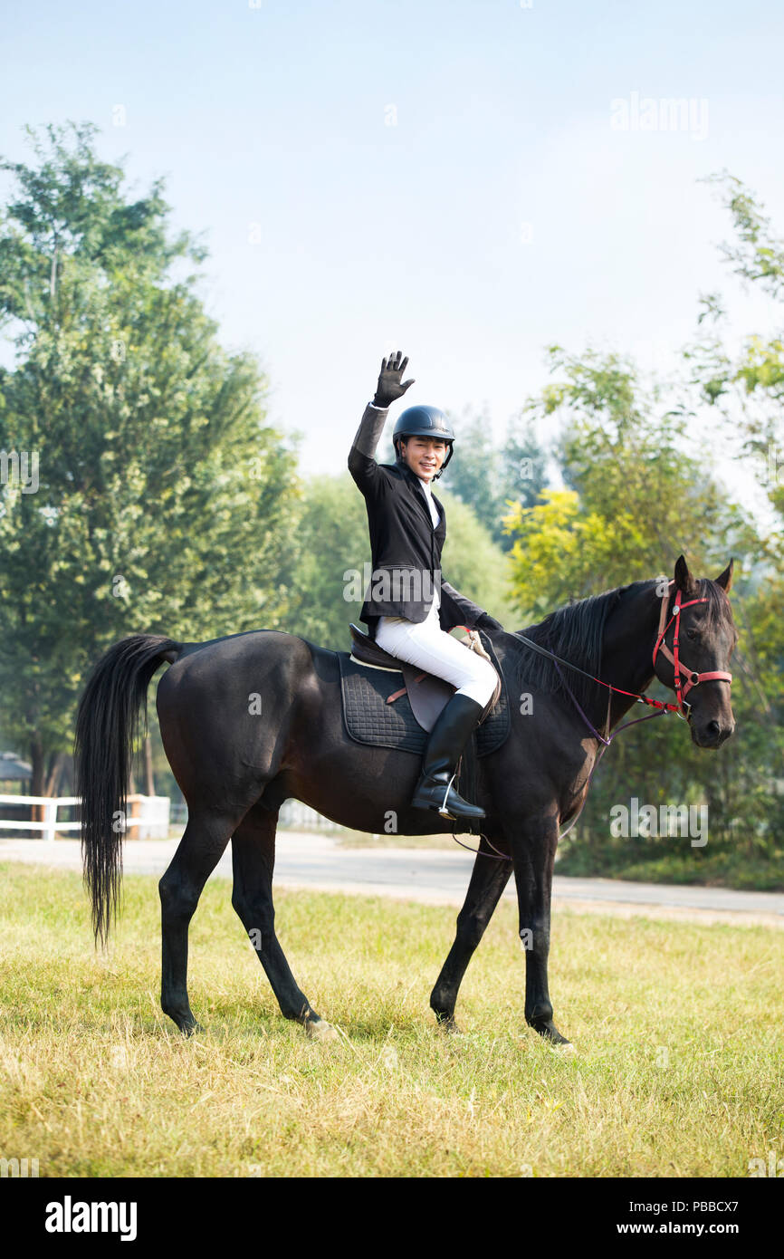 Young Chinese man riding horse Stock Photo - Alamy