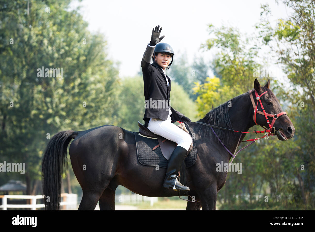 Young Chinese man riding horse Stock Photo - Alamy