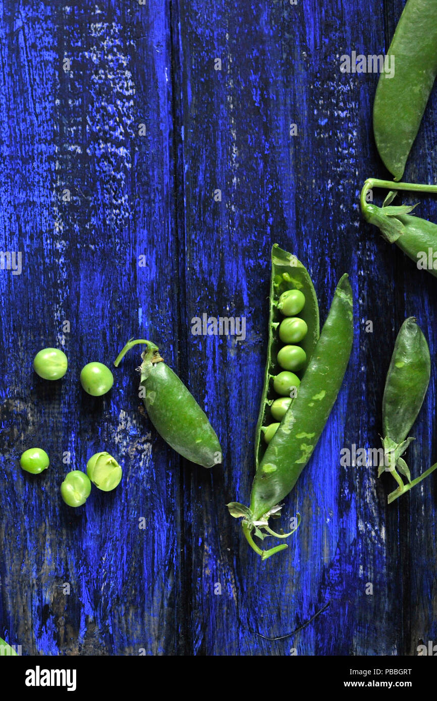 green peas on a blue wooden background, copy space Stock Photo - Alamy