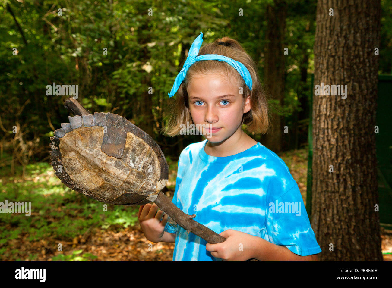 A young girl with stunning, blue eyes, holds a decaying shell of a ...