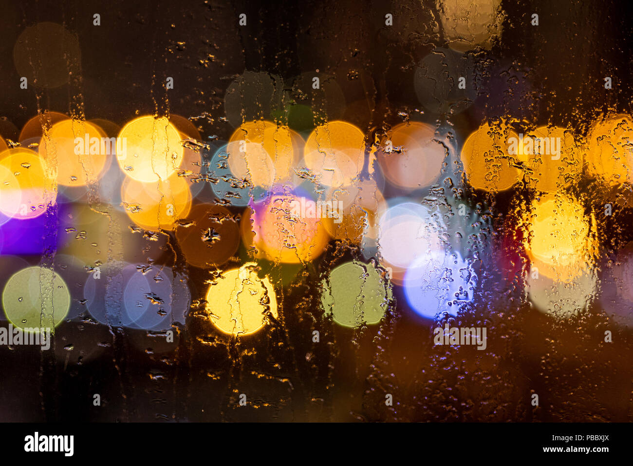 Car lights through rain drops on windscreen hi-res stock photography ...