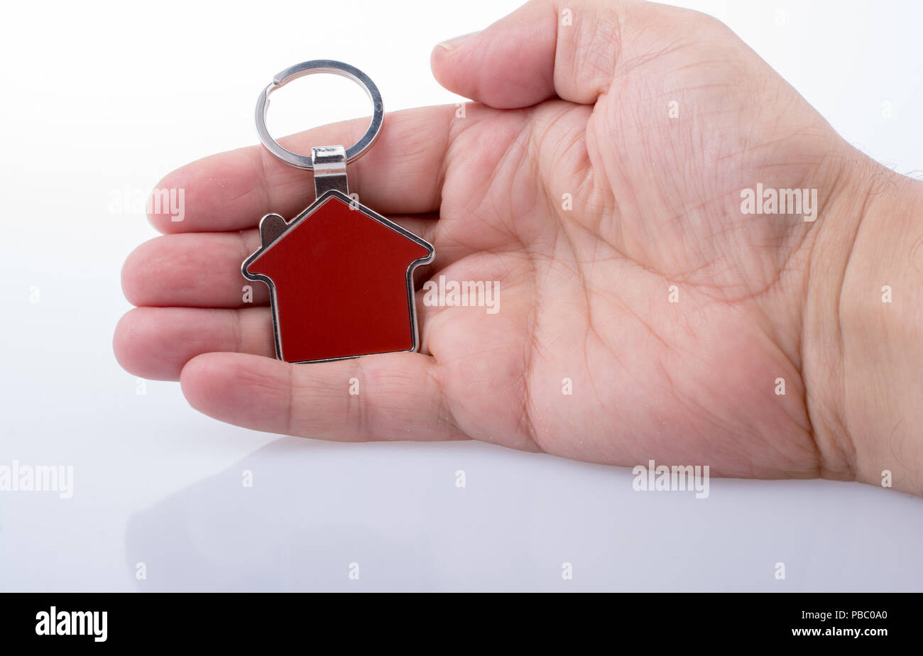 Real estate concept with a metal house icon in hand Stock Photo - Alamy