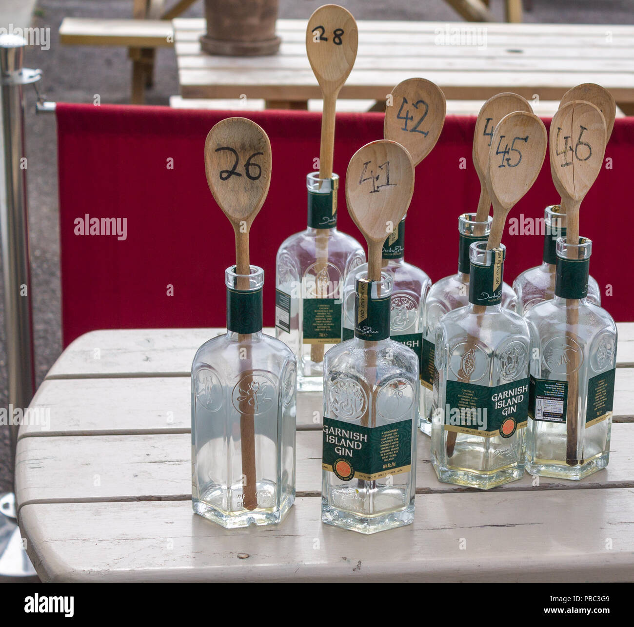empty gin bottles with numbered wooden spoons being used for table ...