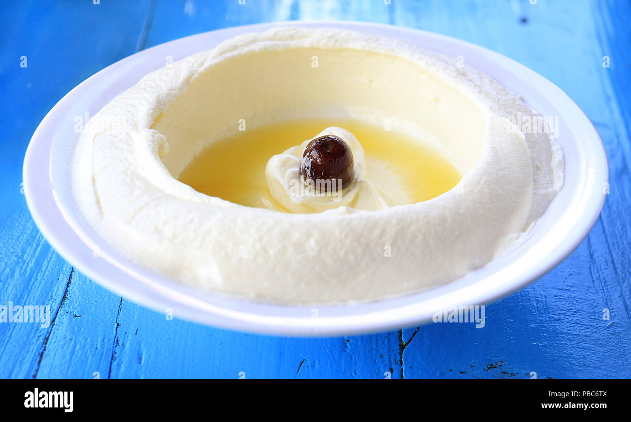 A fresh labneh plate with olive oil on a rustic blue wooden table Stock ...