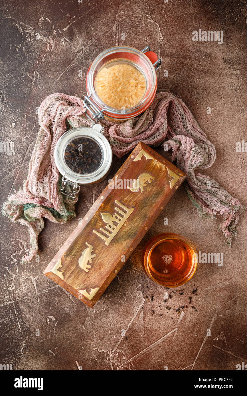 Glass cup of hot tea with jars of different kinds of tea - black, green ...