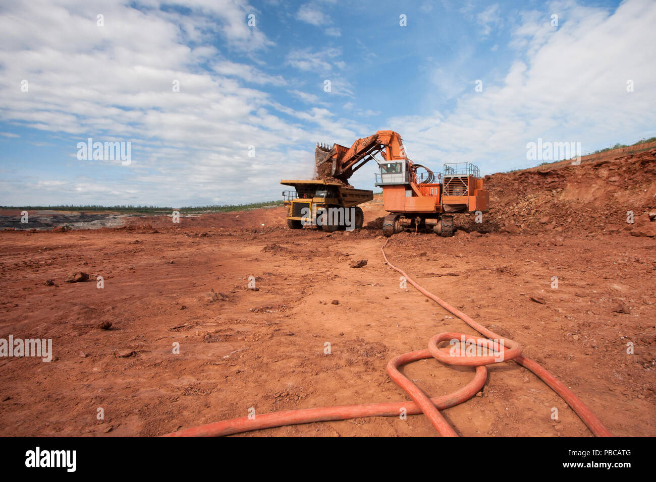 Truck is being loaded with ore at a mine site Stock Photo - Alamy