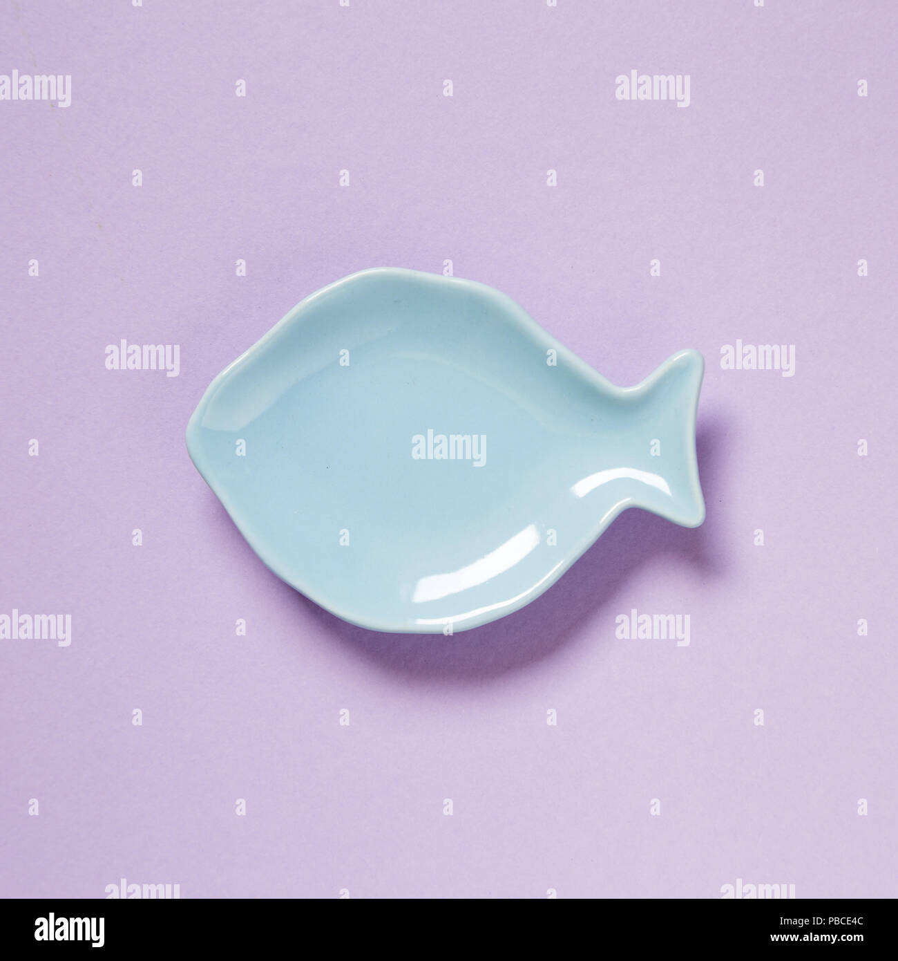 Fish shaped dish isolated on purple background Stock Photo - Alamy