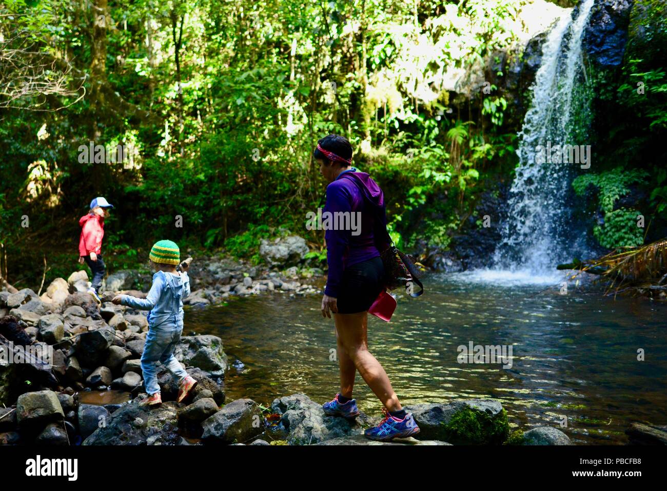 Children walking past a mountain waterfall, Silver falls, Nandroya ...