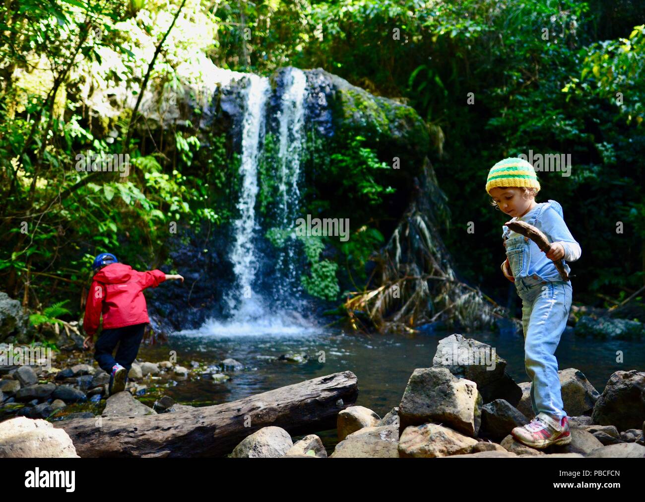 Children walking past a mountain waterfall, Silver falls, Nandroya ...