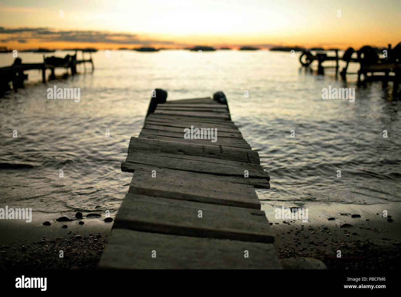 Rustic jetty in the centre of the focus. Late afternoon sunset. Bolivia ...