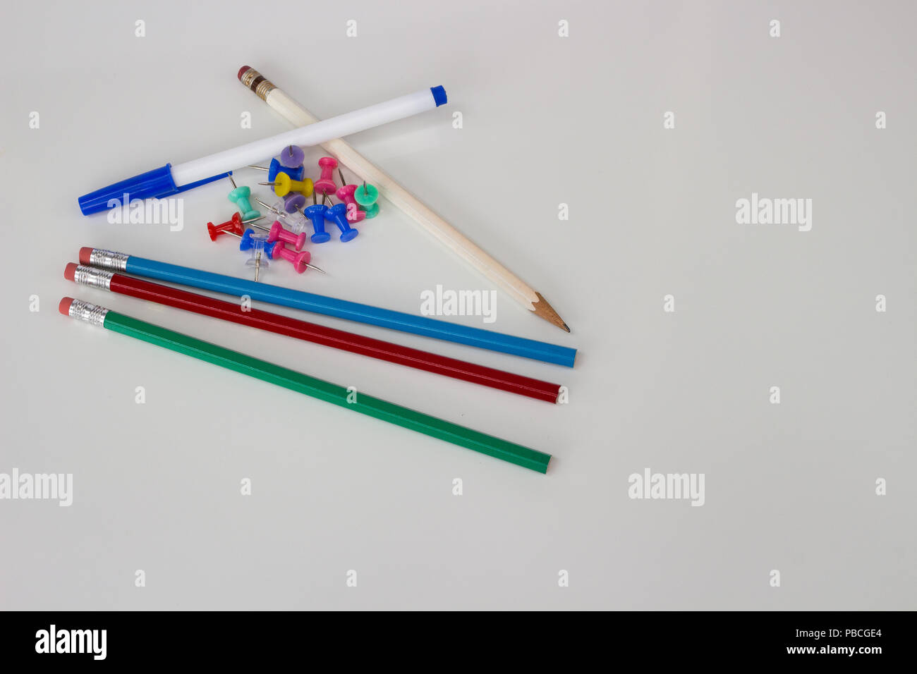 Push pins, pencils and a pen on a white background Stock Photo - Alamy