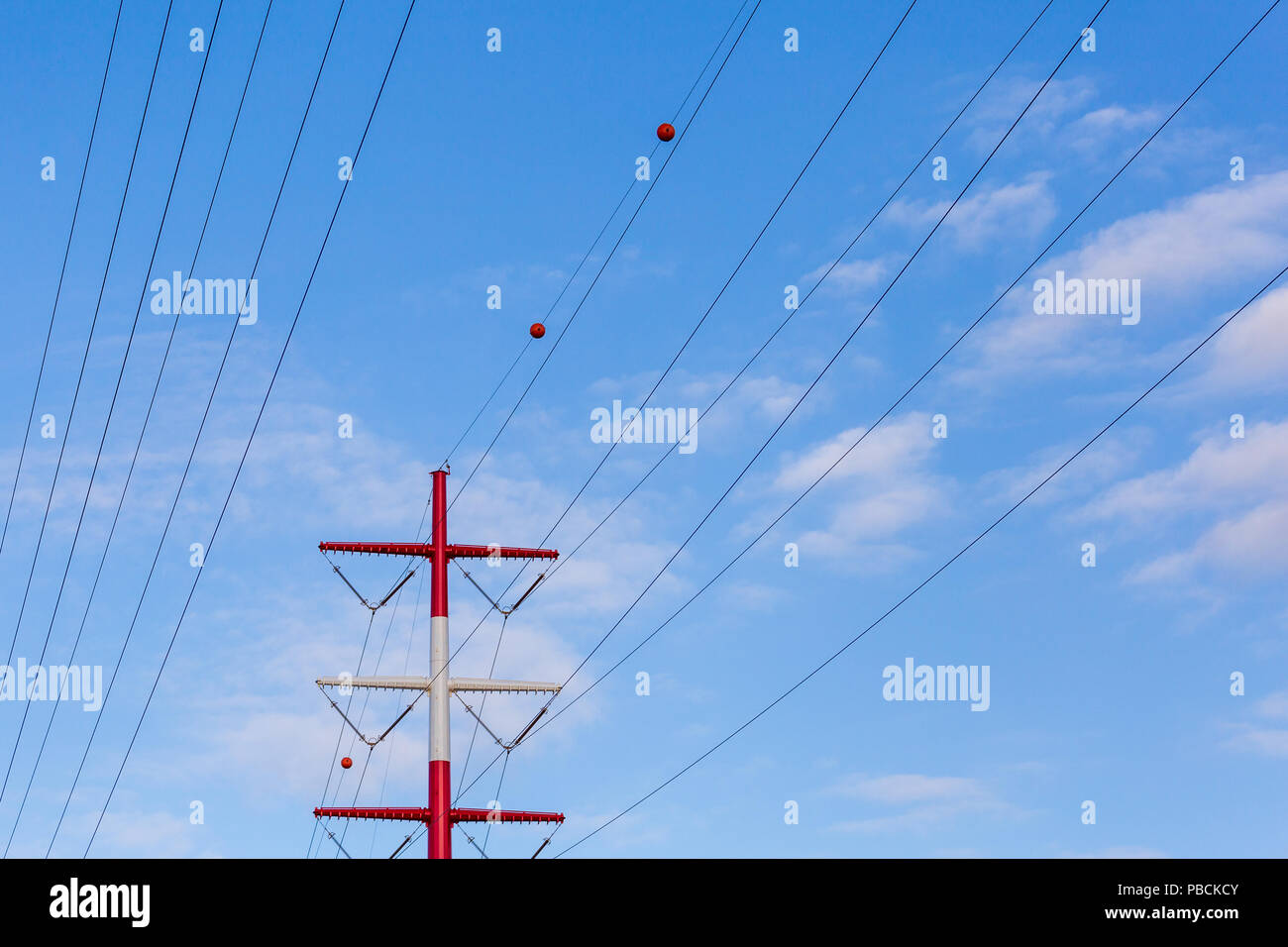 Red and white electric line pole Stock Photo - Alamy