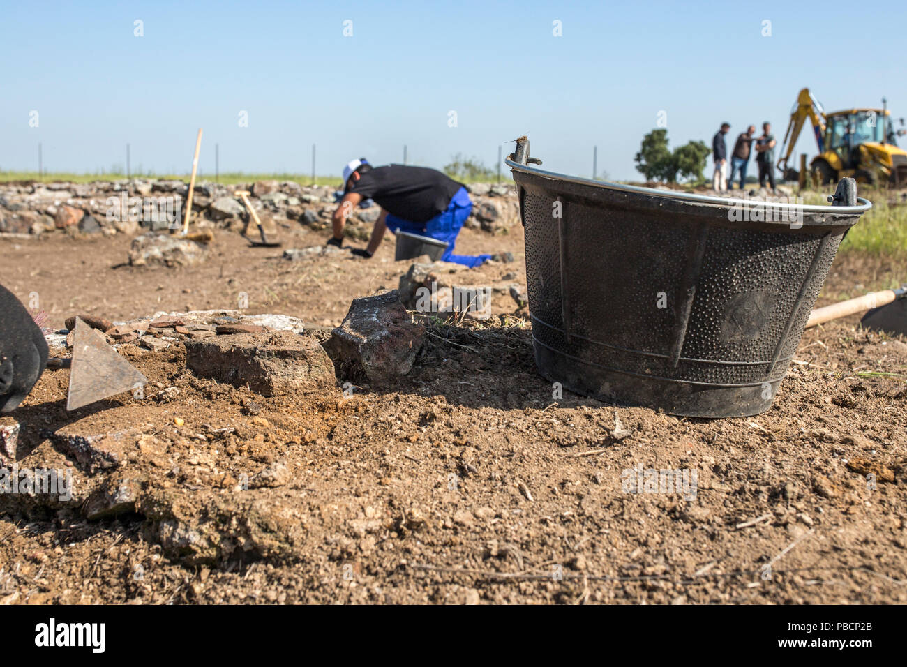 Specialized workers digging with trowel at archaeological excavation ...