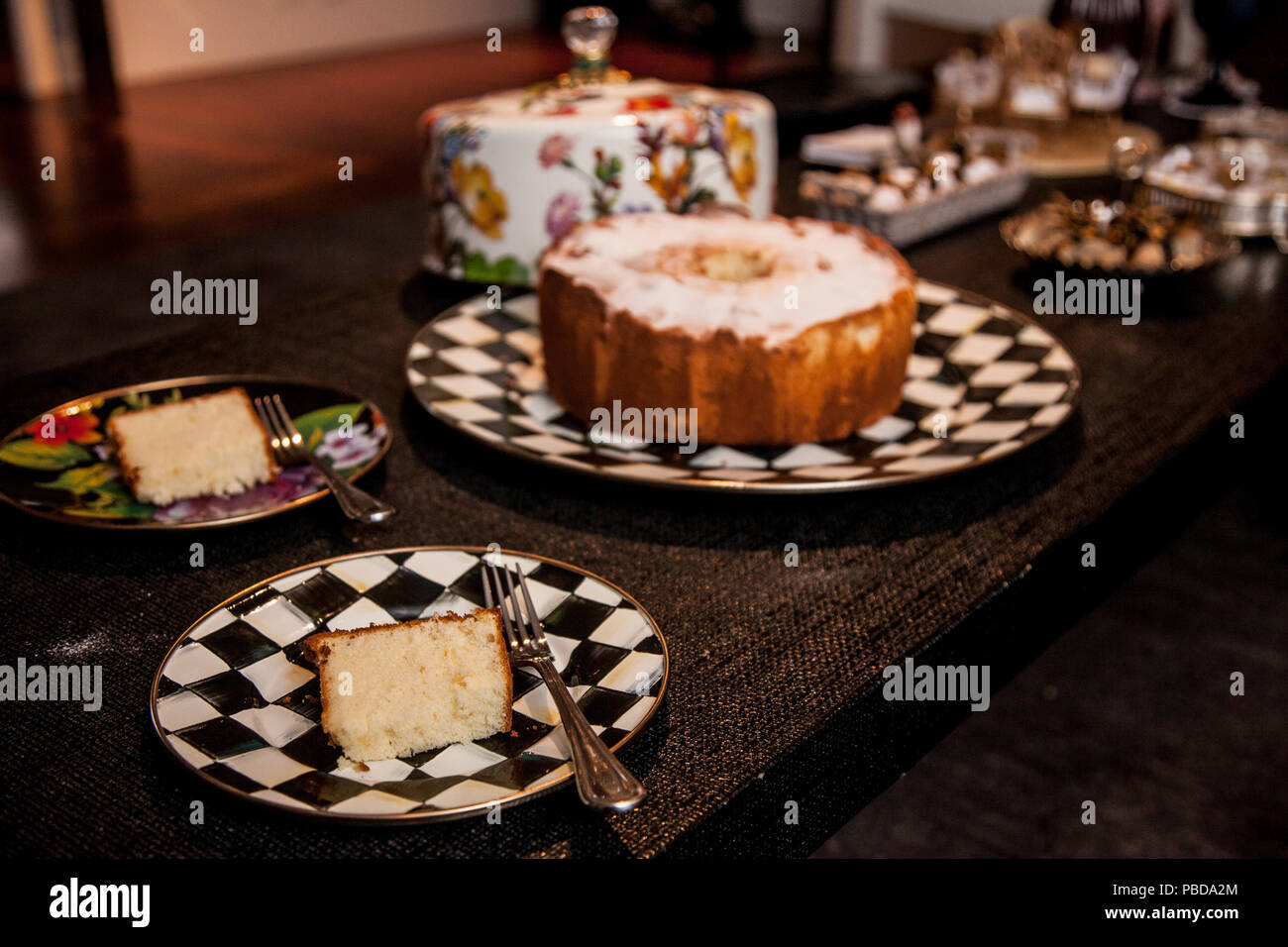 slice of cake with powder sugar on top on a dark wood background ...