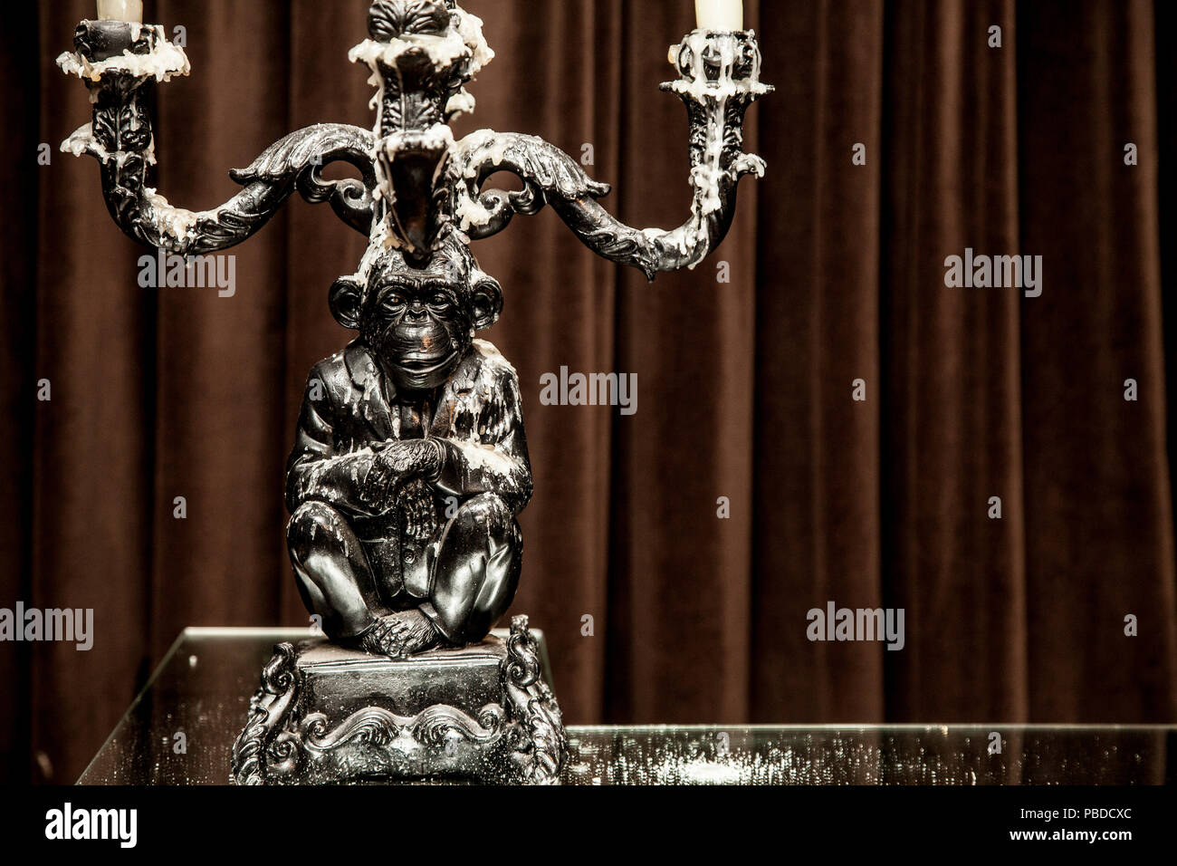 silver candle holder with candles lit on a table. brown background ...