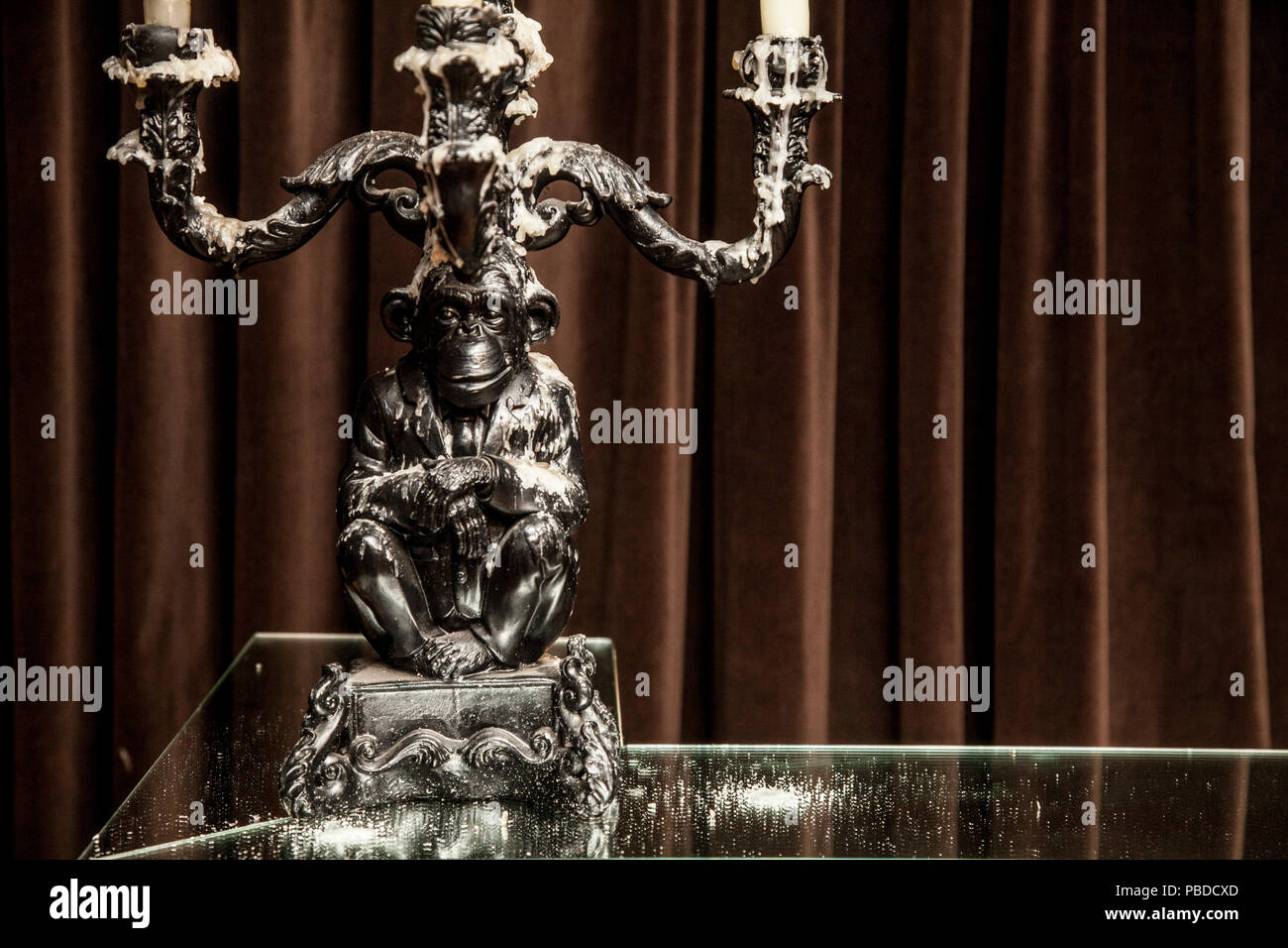 silver candle holder with candles lit on a table. brown background ...