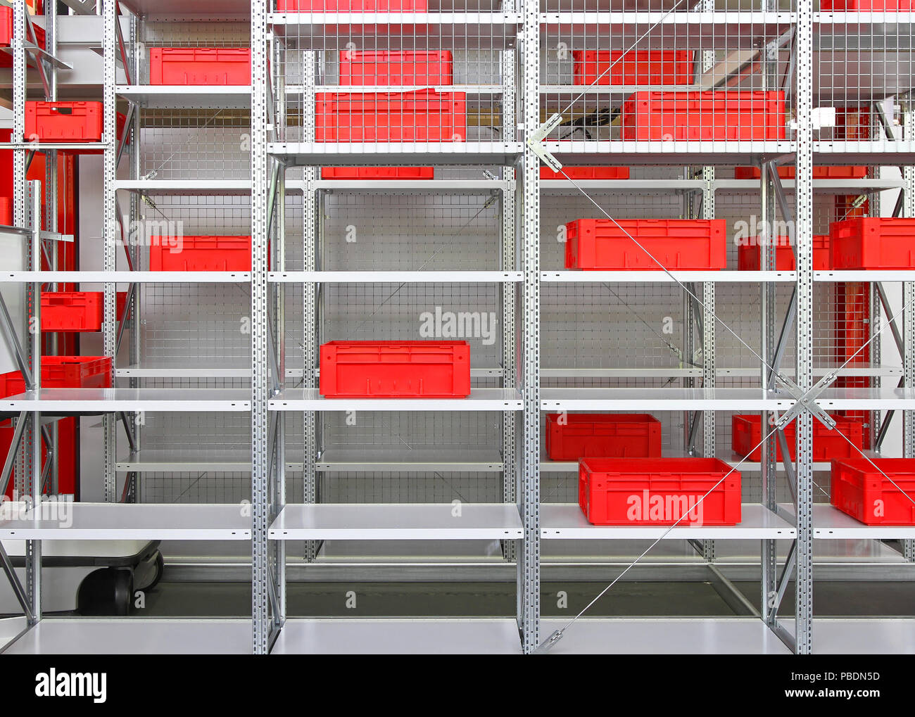 Red boxes and crates at shelves in distribution warehouse Stock Photo ...