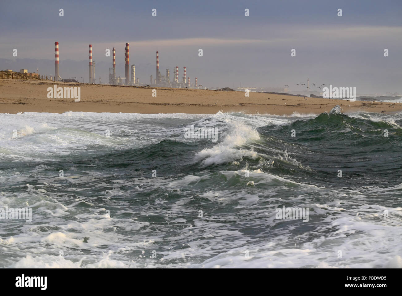 Oil refinery near a beach as seen from the sea Stock Photo - Alamy