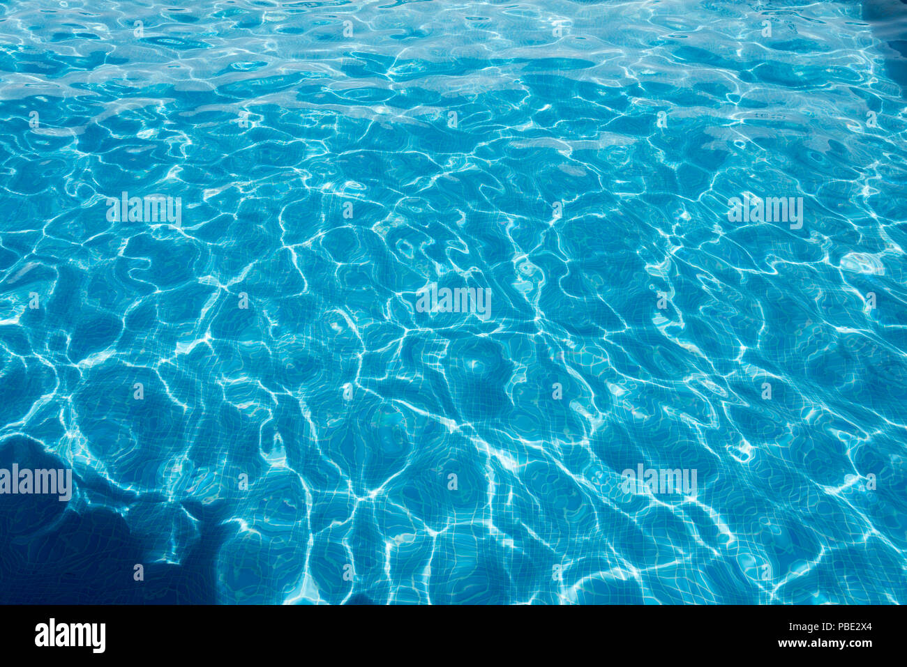 Texture created by the sun's reflections on the water in a blue pool ...