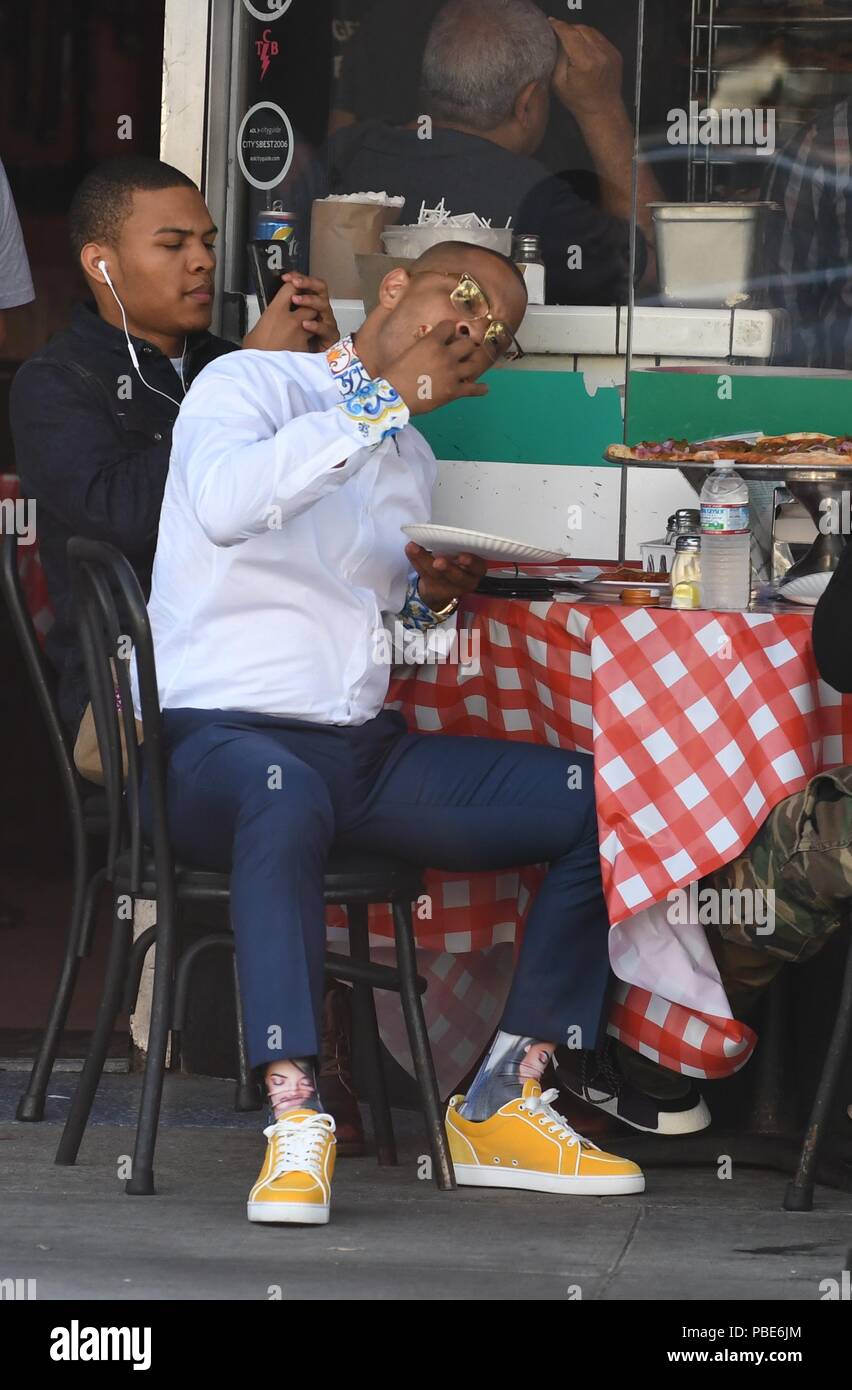 Hip-hop artist T.I. enjoys a slice of pizza at a restaurant with his ...