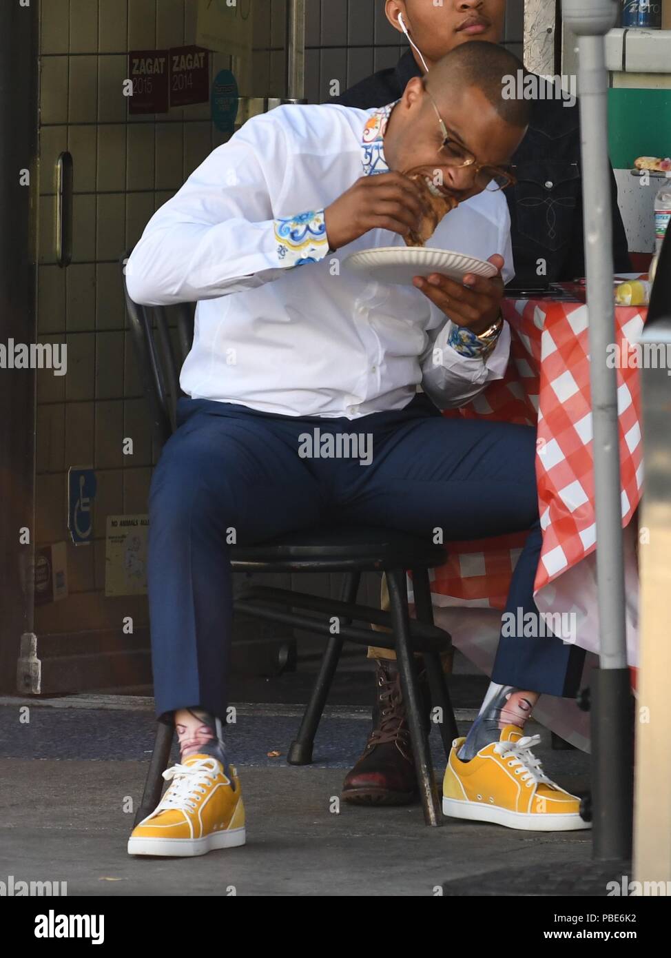 Hip-hop artist T.I. enjoys a slice of pizza at a restaurant with his ...