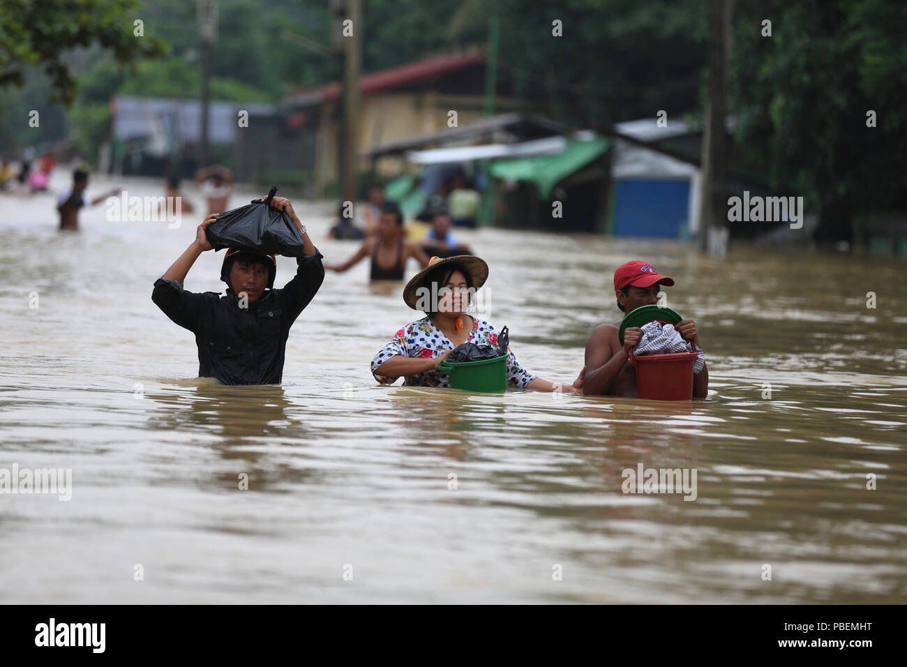 Bago, Myanmar. 28th July, 2018. Residents wade through flood water in ...