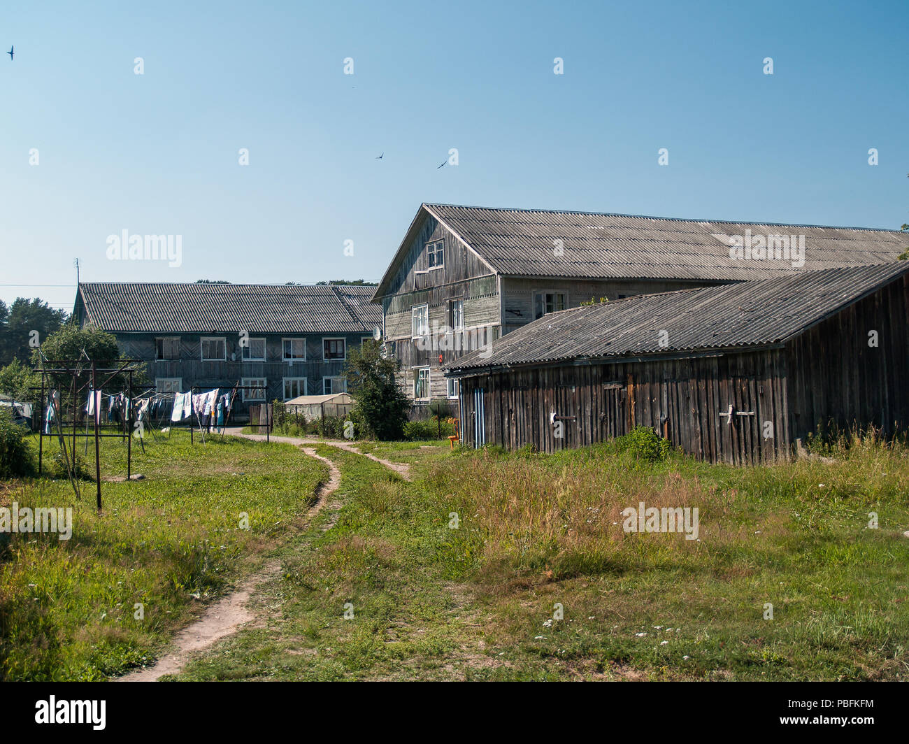 Wooden rural two-story houses with an extension of a barn are on a ...