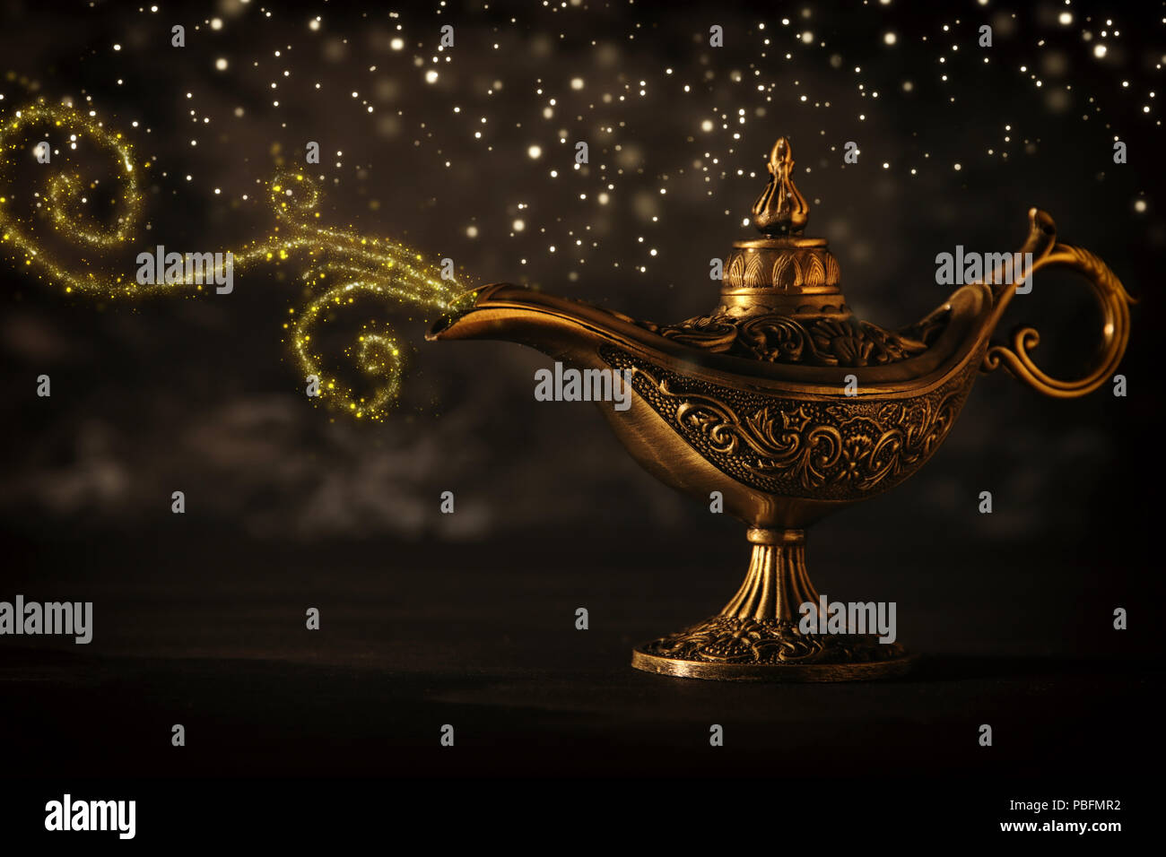 Image of magical mysterious aladdin lamp with glitter sparkle smoke over black background. Lamp ...