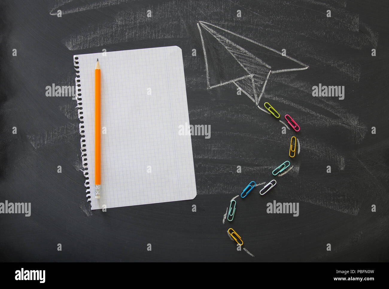 Top view image of plane sketch next to empty notebook paper over ...