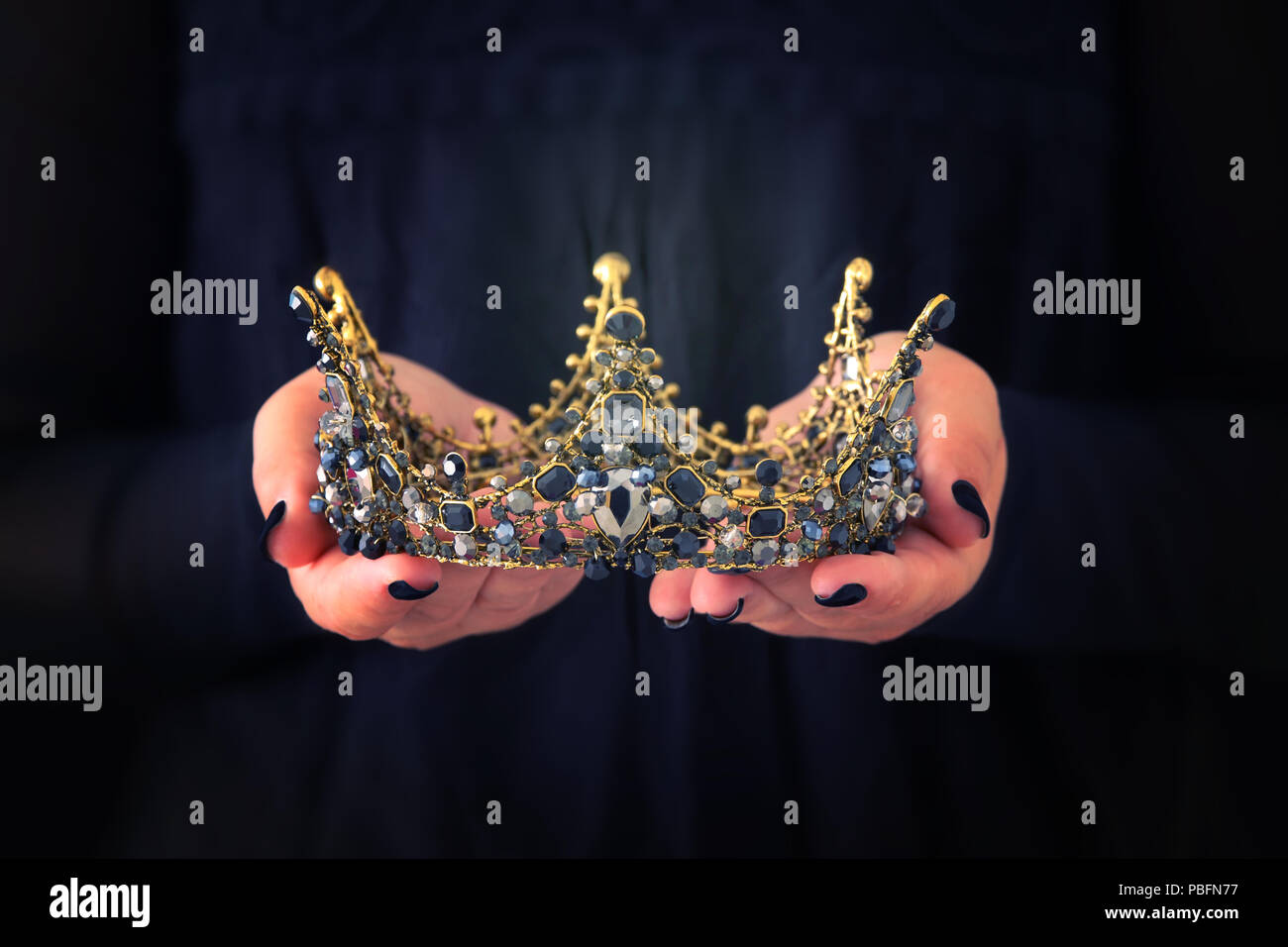 image of lady in black holding queen crown decorated with precious ...