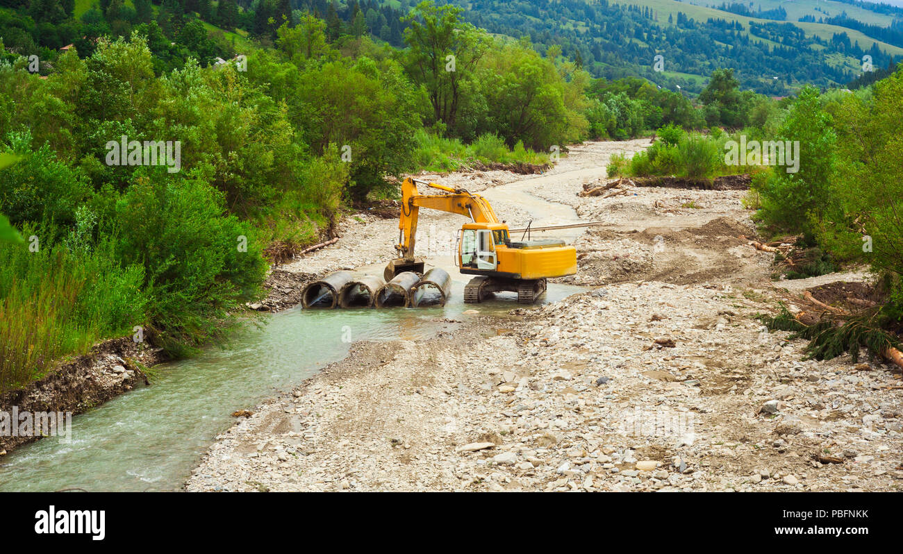 excavator industrial machine building a small bridge over water Stock ...