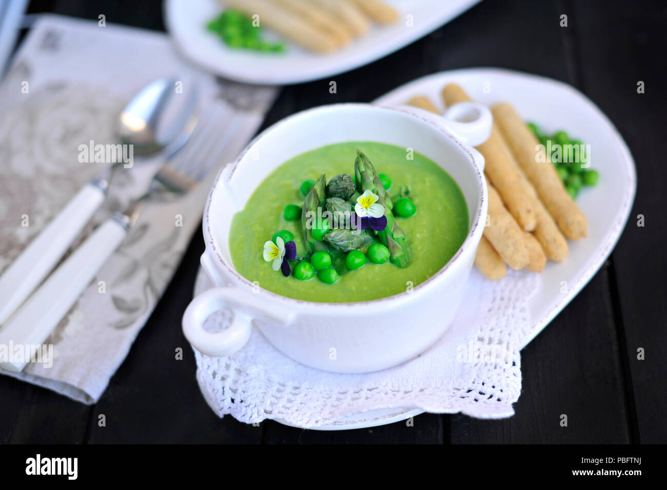 soup puree with green peas and asparagus. decorated with fresh flowers ...