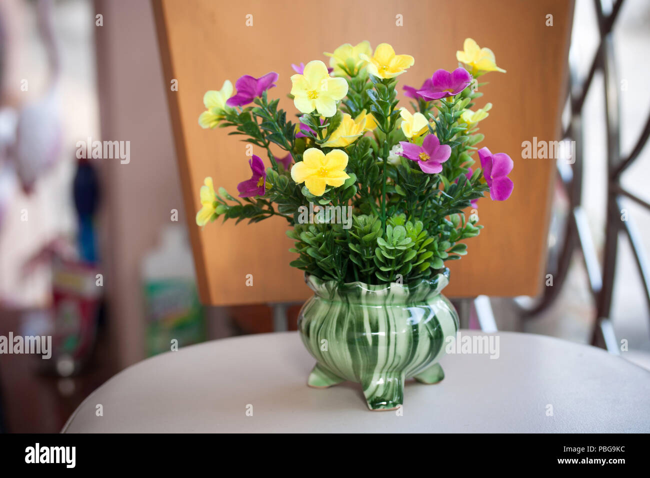 Plastic flower in vase on table Stock Photo - Alamy