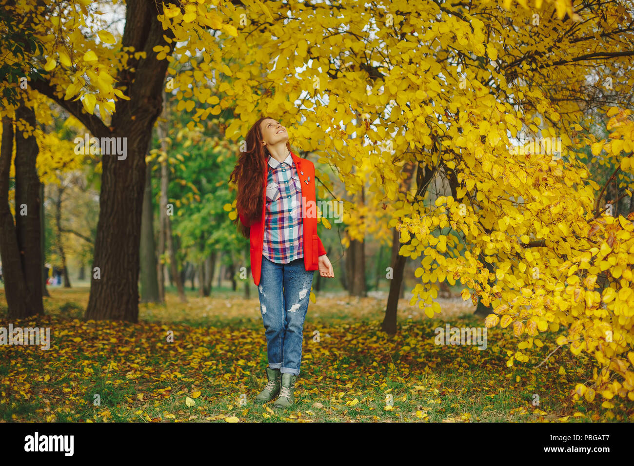 Happy girl looking excited to autumn trees Stock Photo - Alamy