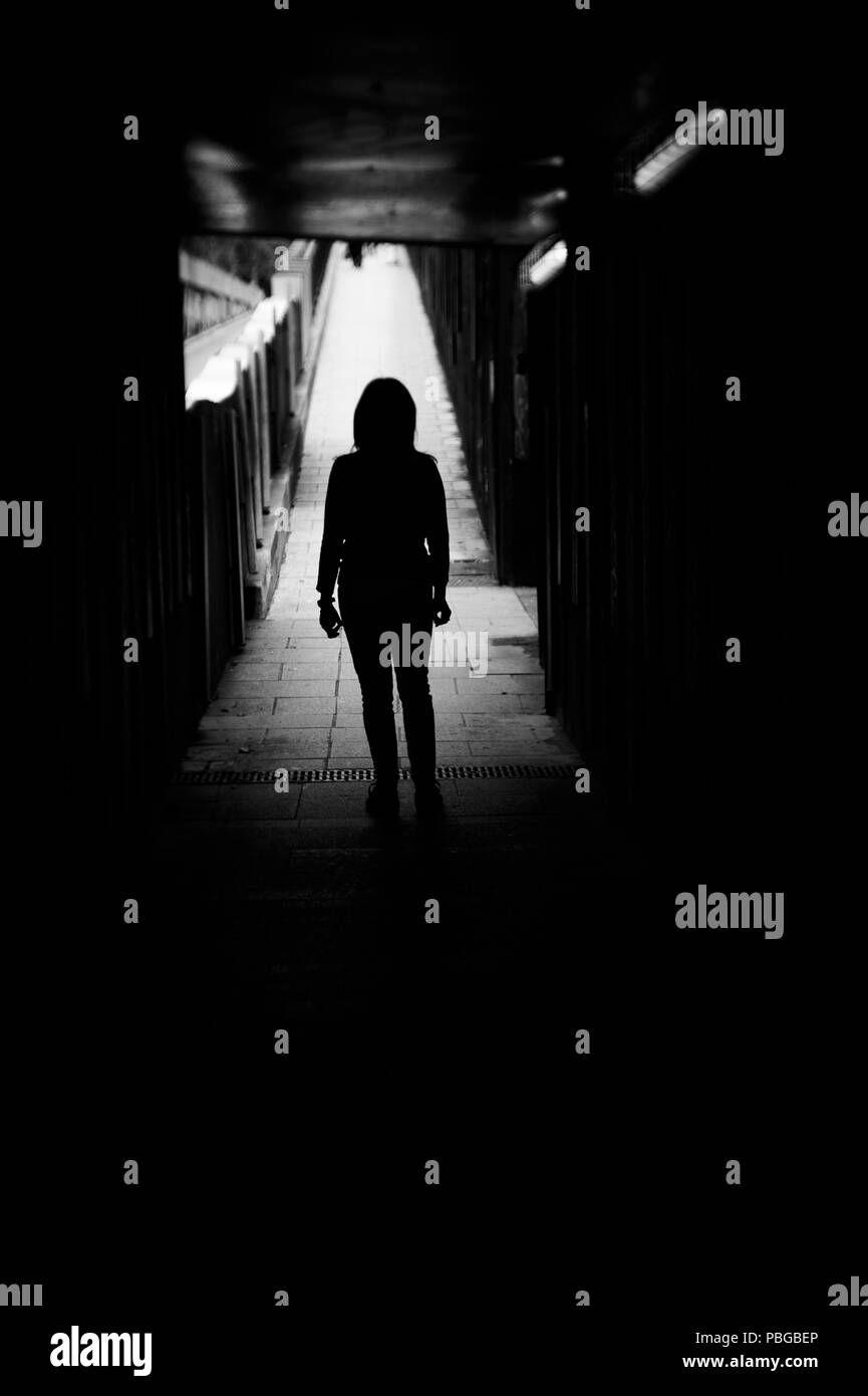 Woman alone and sad in a tunnel. Scene of mystery and desolation Stock ...