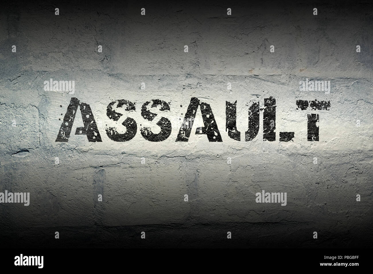 assault stencil print on the grunge white brick wall Stock Photo - Alamy
