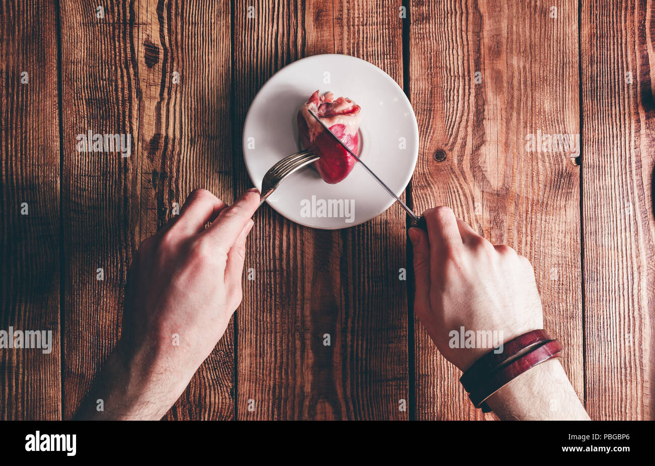 Two Hands Cut the Raw Heart. Top view Stock Photo - Alamy