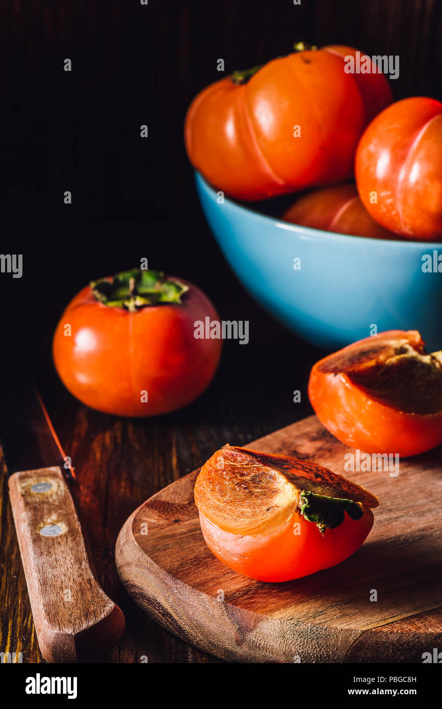 Persimmon Slices with Knife and Some Fruits in Blue Bowl on Background ...