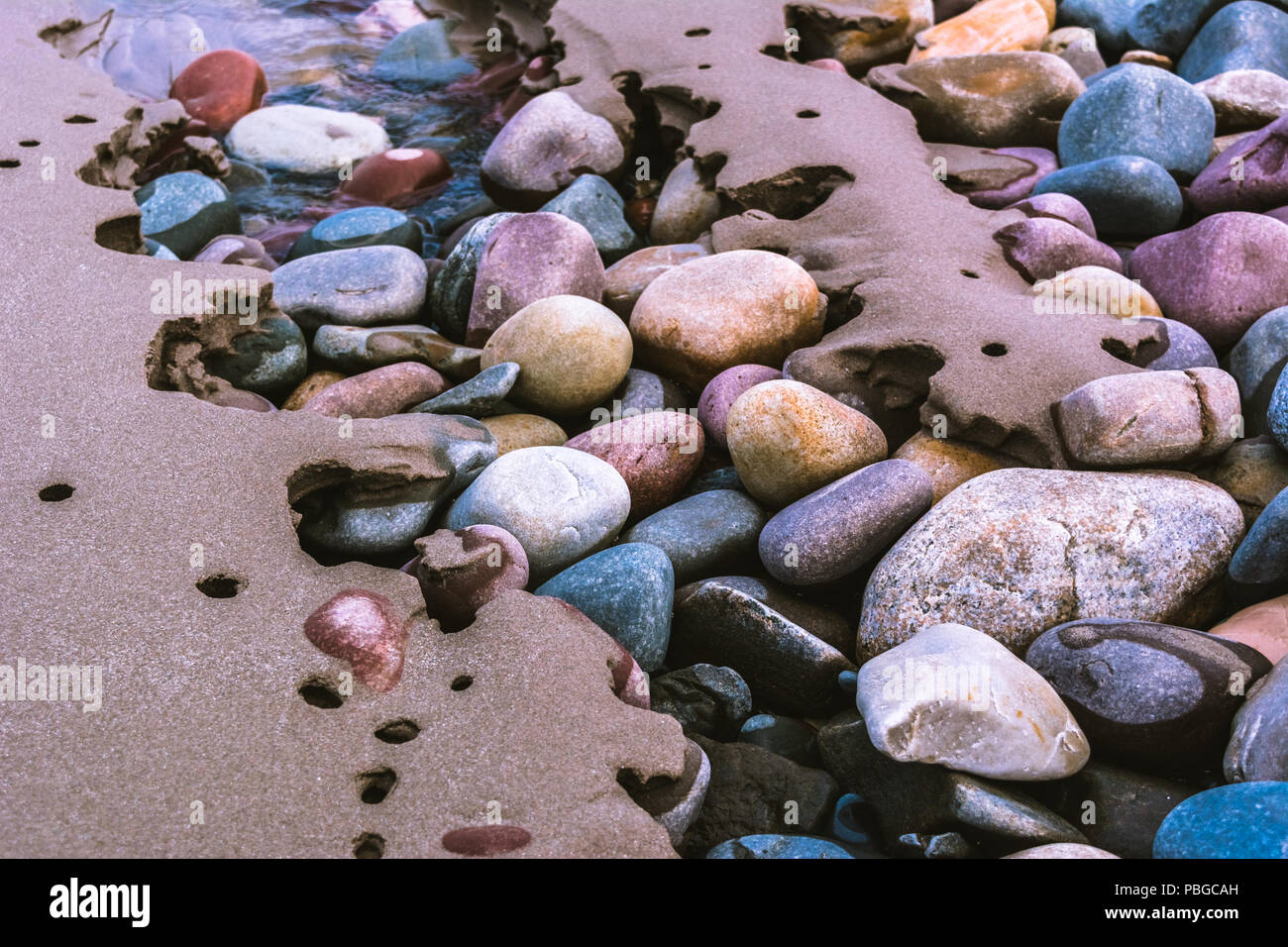 Colour stones on the seaside with sabnd Stock Photo - Alamy