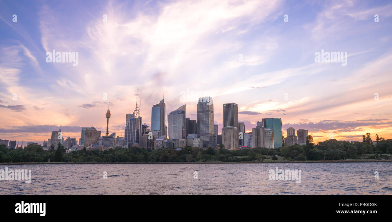 Sydney harbour cityscape at dusk with colourful sunset sky and clouds ...