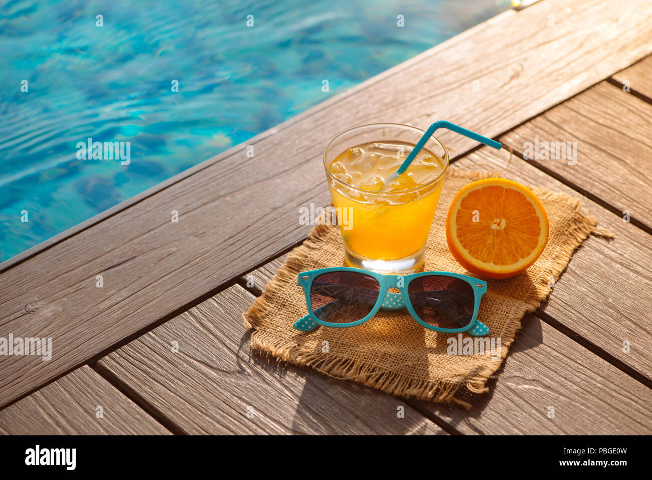 Orange fresh juice smoothie drink, sunglasses near swimming pool Stock ...