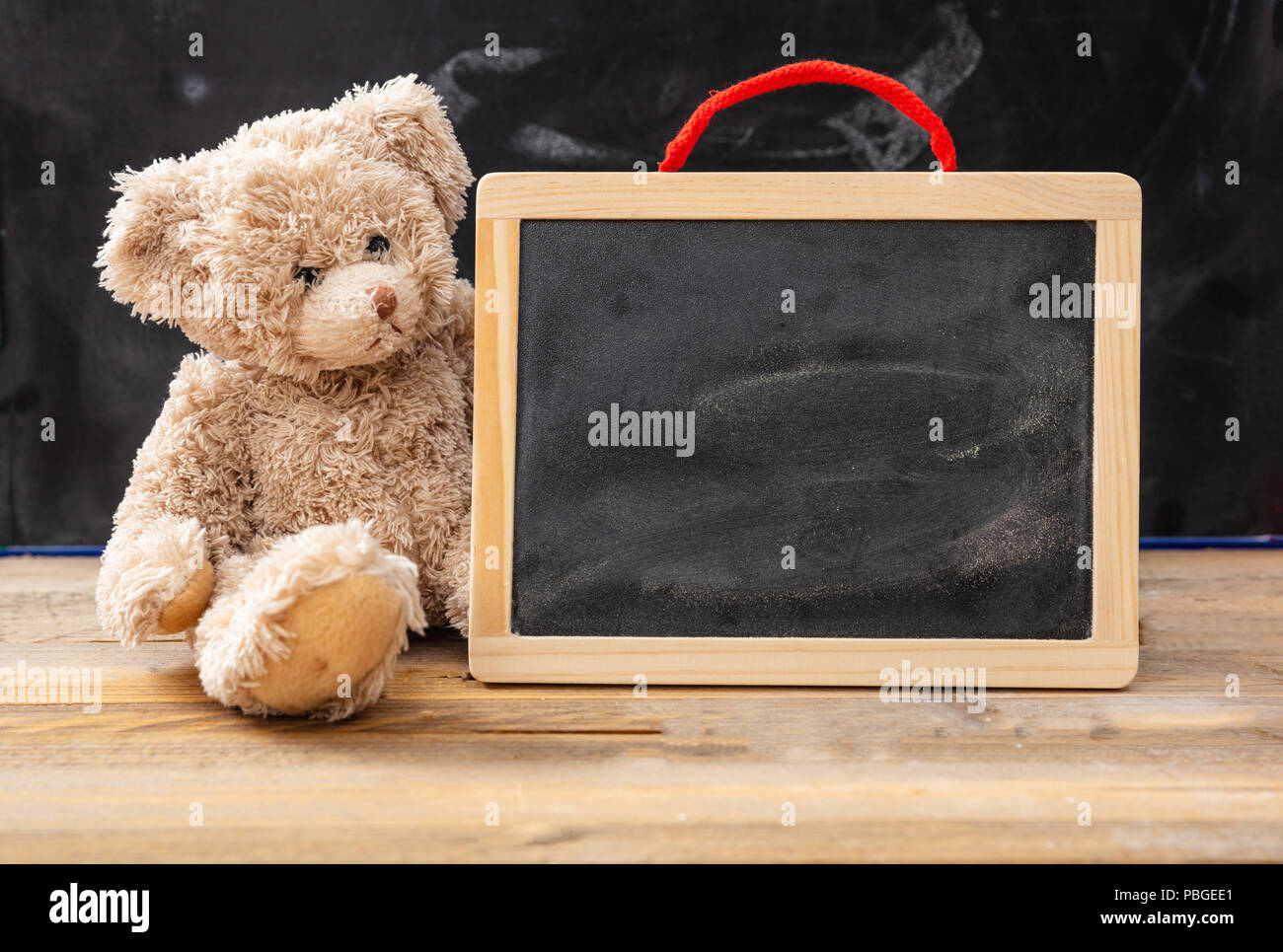 Back to school. Teddy bear and blank blackboard with frame on wooden ...