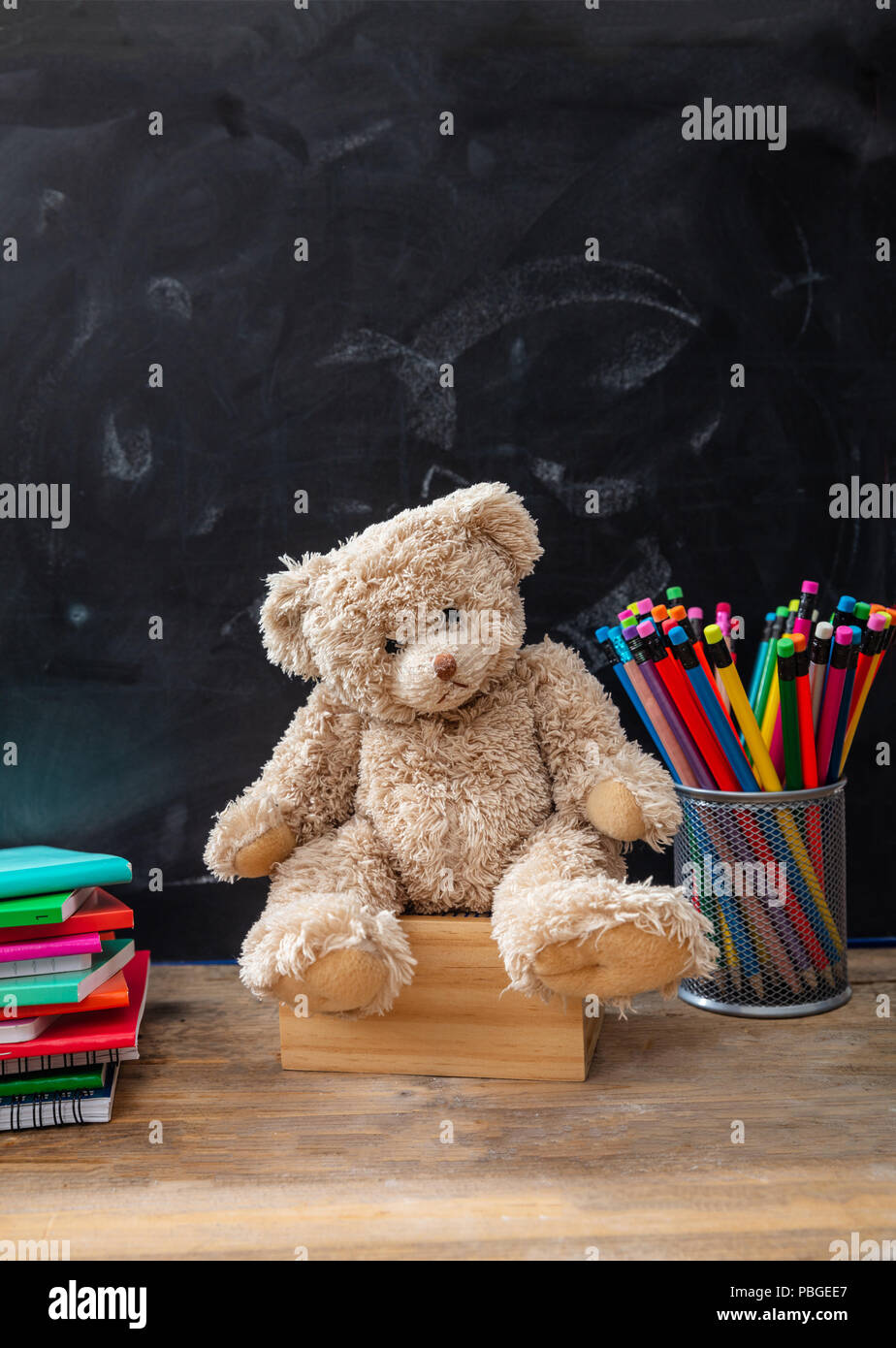 Back to school. Teddy bear and colorful pencils and notebooks on ...